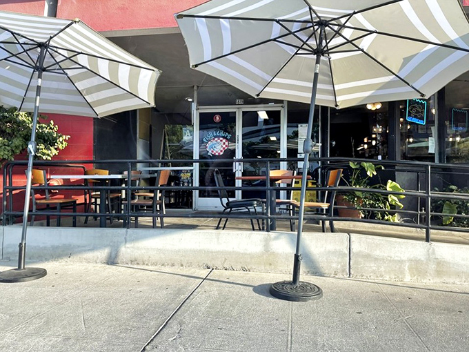 Outdoor seating under striped umbrellas offers a perfect spot for people-watching while savoring those legendary fish and chips.