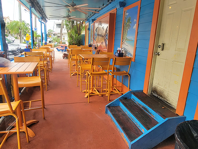 Bright blue walls and orange chairs create a tropical oasis on the patio. This splash of Caribbean color is the perfect setting for seafood that was swimming this morning.