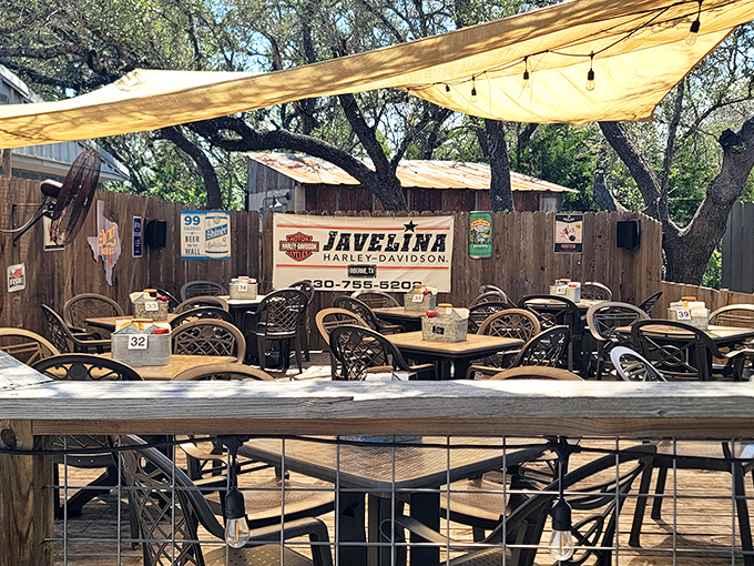 Outdoor seating under shade trees where Harley signs and wooden tables create the perfect Texas atmosphere for contemplating life's big questions&mdash;like ordering seconds.