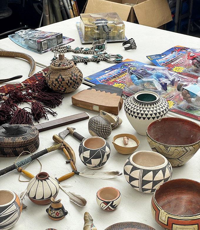 Native American pottery meets collectible treasures in this eclectic display where traditional craftsmanship and pop culture memorabilia create an unexpected harmony.