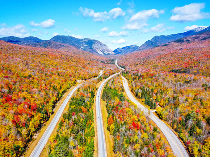 Roads that curve like nature's roller coaster. Fall foliage transforms Franconia Notch into a kaleidoscope of colors that no filter can improve.