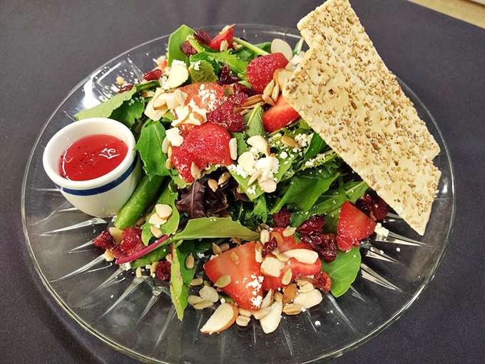 This vibrant salad proves healthy eating needn't be boring &ndash; strawberries, almonds, and greens create a colorful composition worthy of the crystal plate it's served on.