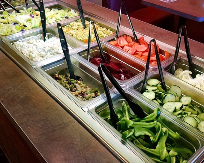 Fresh ingredients lined up like soldiers ready for duty. The salad bar offers a rainbow of options for the virtuous or the guilt-ridden.