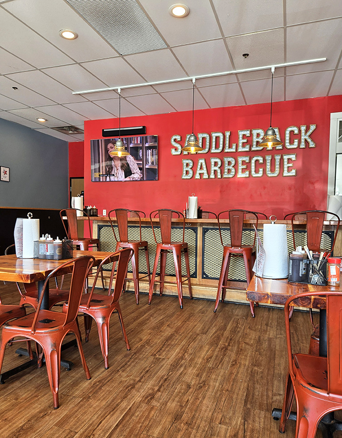 The bold red wall and metal chairs create a no-nonsense atmosphere that says, "We're here for the meat, not the frills."