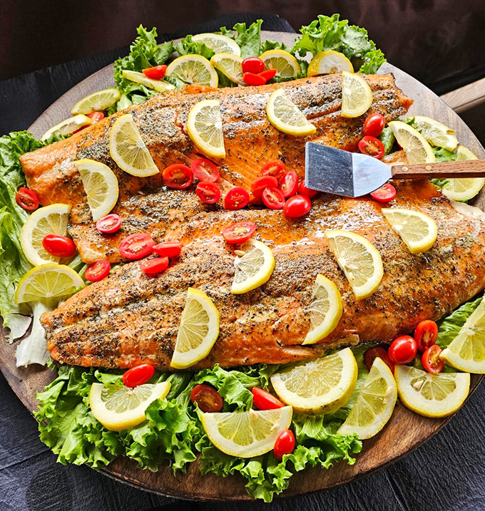This isn't just salmon &ndash; it's an aquatic masterpiece, dressed for success with lemon slices and cherry tomatoes on its bed of greens.
