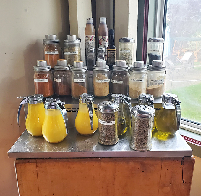 The secret weapons arsenal&mdash;house spices and condiments lined up like soldiers ready for flavor battle. Those yellow squeeze bottles? Liquid gold.