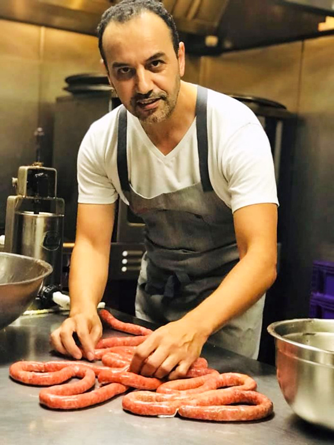 Behind every great restaurant is a passionate chef, and here we see the artistry of handcrafting what appears to be the restaurant's signature merguez sausage.