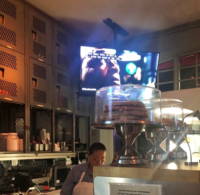 Behind the scenes where desserts await their moment of glory. In the background, life continues while cakes stand ready for their close-up.