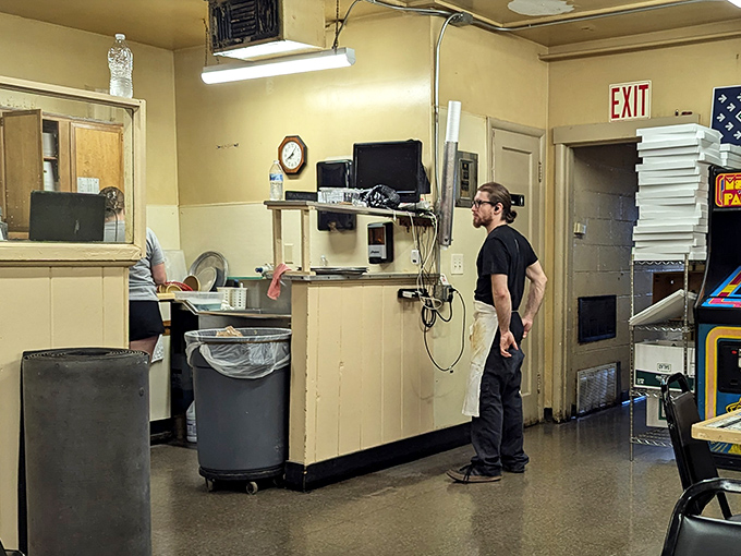 Behind the counter, where pizza magic happens with the efficiency that comes only from decades of practice and unwavering dedication to the craft.