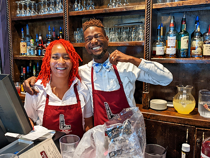 Staff wearing crisp white shirts and red aprons share genuine smiles—the kind you can't train for and money can't buy.