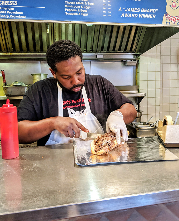 The sandwich craftsman at work, wielding spatula and skill to transform simple ingredients into edible poetry.