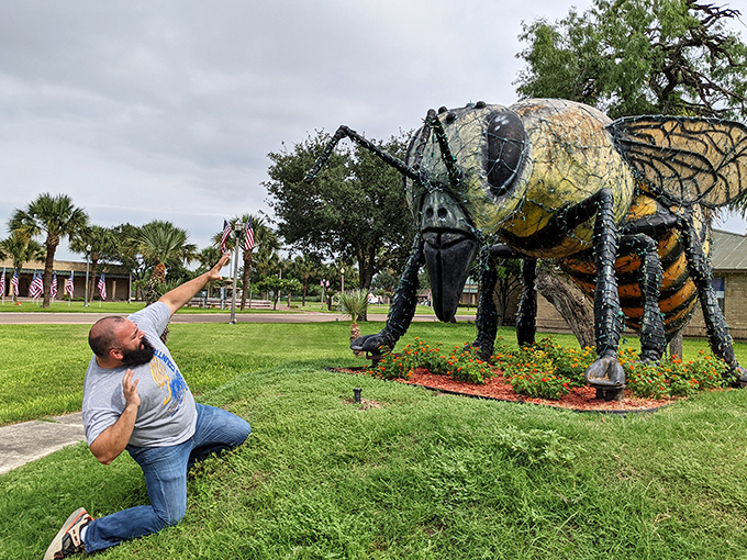Visitors often strike dramatic poses with the statue. This theatrical reaction captures the playful spirit the monument inspires.
