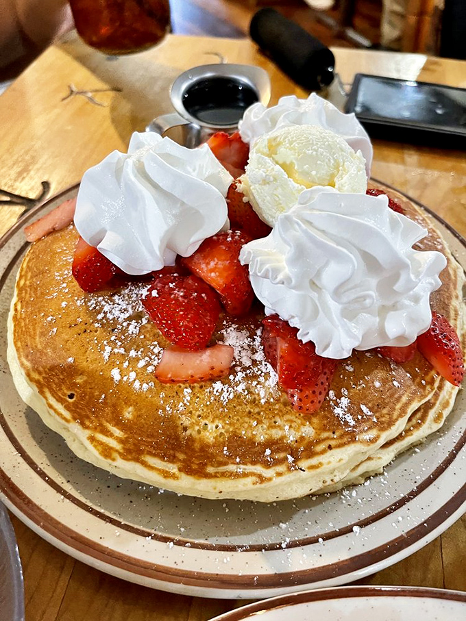 Pancakes that look like they're auditioning for a breakfast cereal commercial, complete with strawberry co-stars and whipped cream special effects.