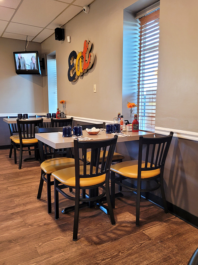 Corner tables bathed in natural light, where "Eat" wall art states the obvious mission that everyone is happy to accept.