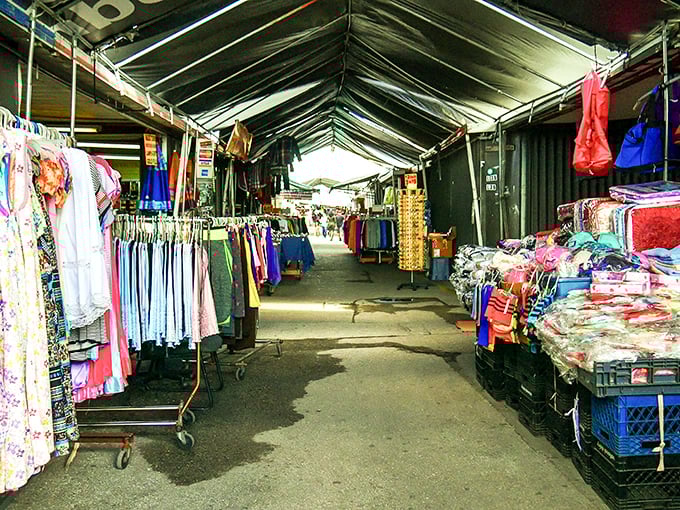 Under the tent's protective embrace, vendors create miniature retail universes where every rack tells a different style story.