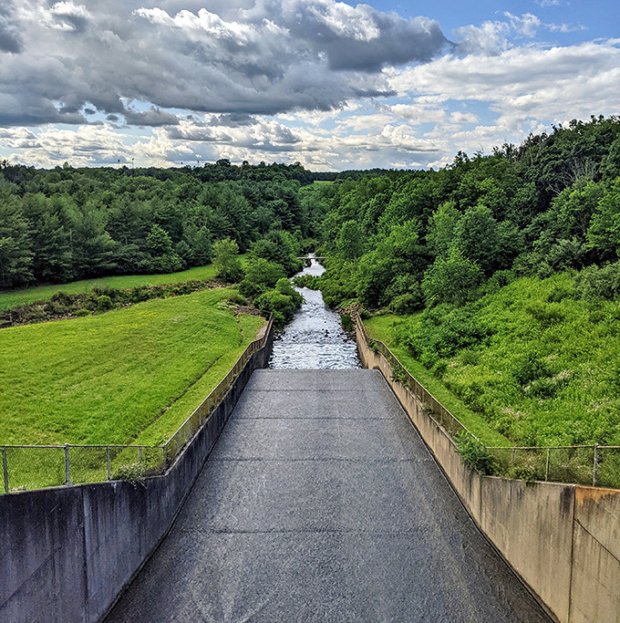 The dam spillway creates its own river symphony, channeling water through concrete corridors back to the wild.