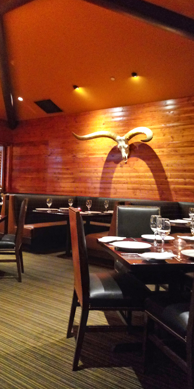 A longhorn skull mounted on warm wooden walls watches over diners like a guardian of good taste. The leather booths below have witnessed countless celebrations and first dates.