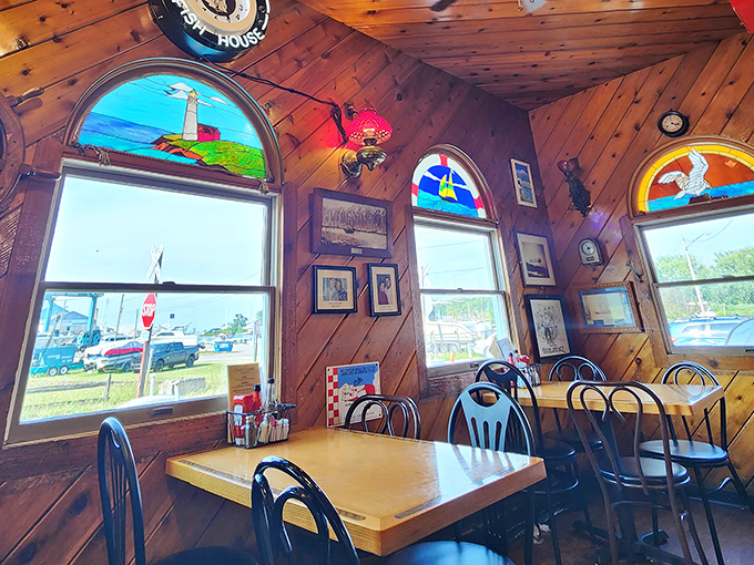 Stained glass windows filter light onto simple wooden tables, creating the perfect setting for seafood feasts where the outside world disappears with each delicious bite.