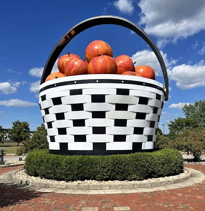 Puffy clouds drift above as the basket's massive handle creates a perfect arch against the brilliant blue Ohio sky.