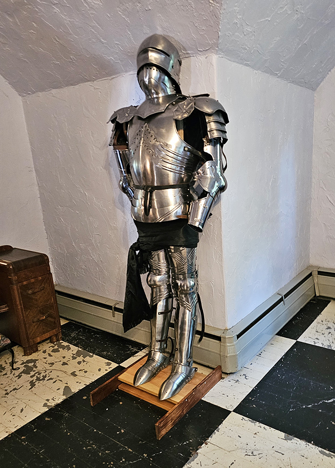 This knight stands eternal watch in the castle corridor, his armor gleaming under soft light like he's expecting a dragon any minute now.