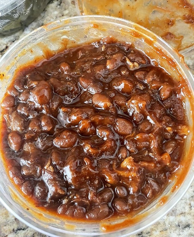 Baked beans swimming in a sauce so rich and complex, they've clearly been simmering since breakfast, plotting their delicious revenge.