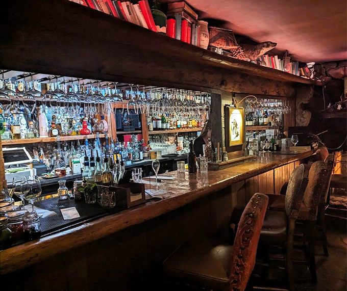 The bar doesn't just serve drinks&mdash;it crafts liquid companions for your meal. Those glasses hanging above promise sophisticated refreshment.