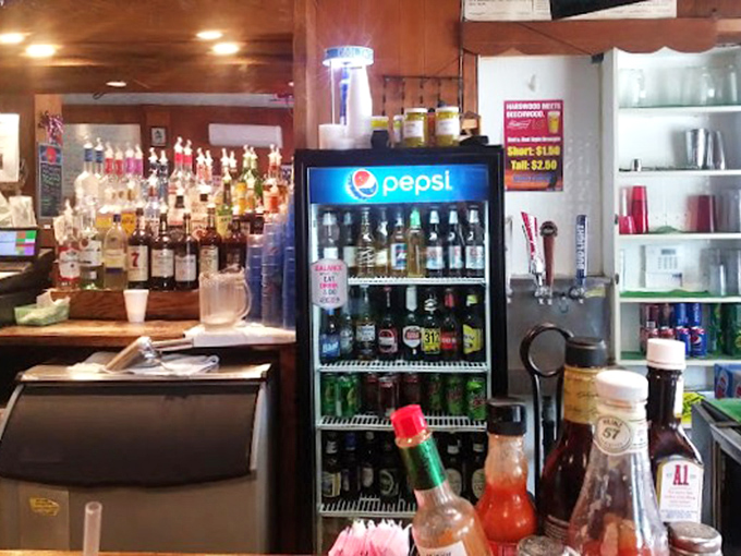 The bar area—where cold beer flows, sports play on screens above, and strangers become friends over shared appreciation of simple pleasures.