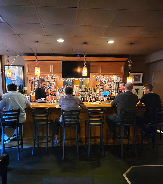 The bar area offers a front-row seat to mixology magic, where Italian spirits transform into cocktails that complement rather than compete with your meal.