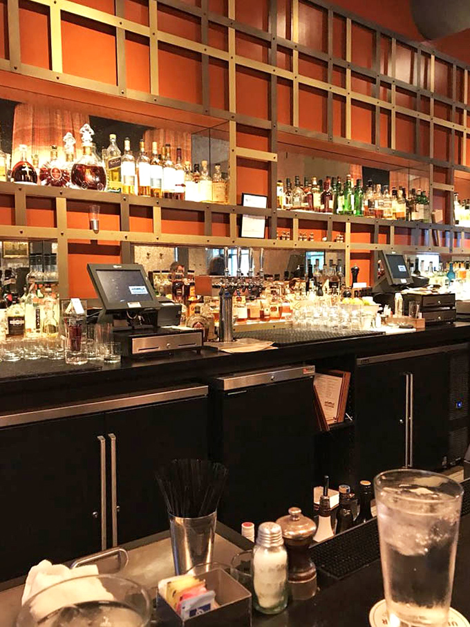 The bar's architectural grid showcases spirits like museum pieces, turning bottle browsing into an art appreciation session with delicious rewards.