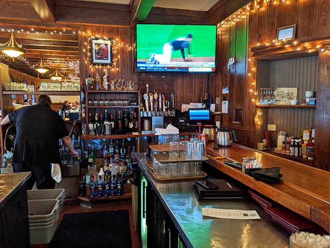 Behind this bar, mixologists craft liquid happiness while sports fans gather to cheer on Indiana teams in wood-paneled comfort.