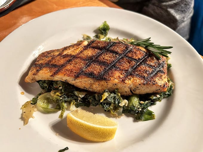 Blackened salmon that flirts with perfection, nestled on a bed of greens. That crosshatch grill mark pattern isn't just cooking—it's edible artwork.