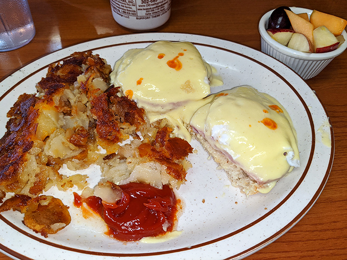 Eggs Benedict with a side of crispy hash browns and a dollop of ketchup for dipping. Breakfast doesn't get more classic &ndash; or more satisfying &ndash; than this.