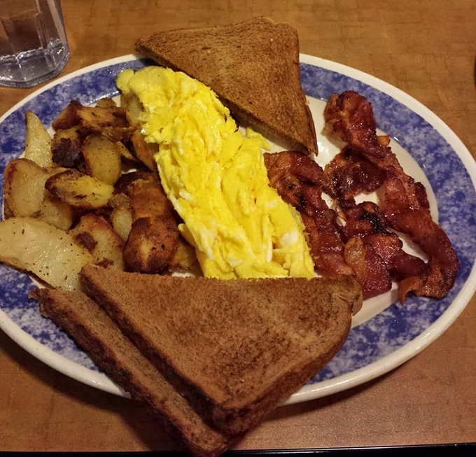 The breakfast platter that launched a thousand productive days: fluffy eggs, crispy bacon, and home fries that could make a morning person out of anyone.