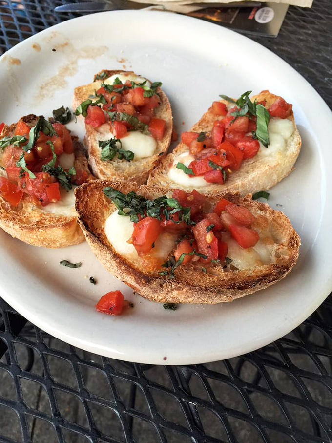 Bruschetta that captures summer in each bite&mdash;toasted bread islands topped with fresh tomato treasures and melted cheese continents.