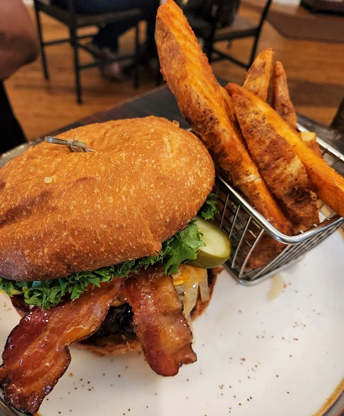 A burger that demands to be photographed before eaten, with those potato wedges standing at attention like they know they're part of something special.