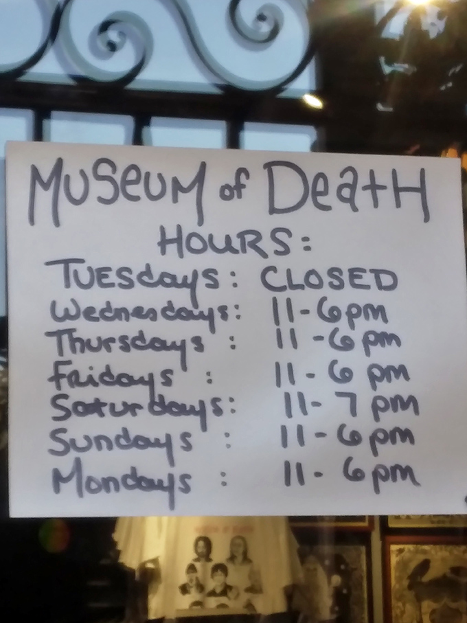 Closed on Tuesdays—even death takes a day off. The handwritten hours add a personal touch to the macabre.