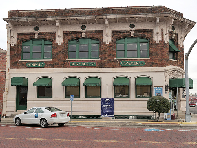 The Mineola Chamber of Commerce building epitomizes small-town architectural grandeur with its brick facade and green awnings, a testament to the town's historic prosperity.