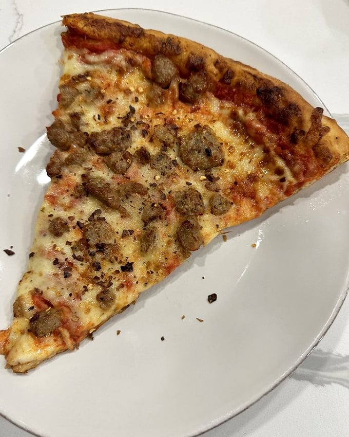 One perfect slice of sausage pizza—the kind that makes you reconsider whether you really need to share the rest of the pie.