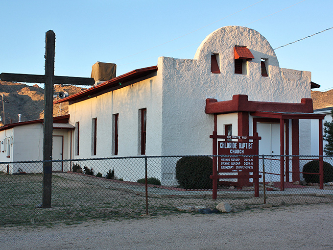 The whitewashed Chloride Baptist Church stands in stark contrast to the rugged mountains behind it &ndash; a spiritual anchor in this desert mining community.