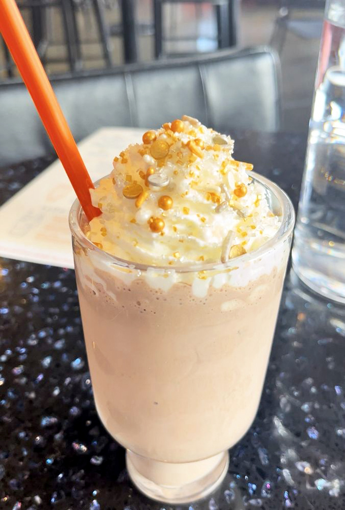 A milkshake topped with whipped cream and golden pearls. Drinking dessert never looked so celestial&mdash;or required such impressive straw strength.