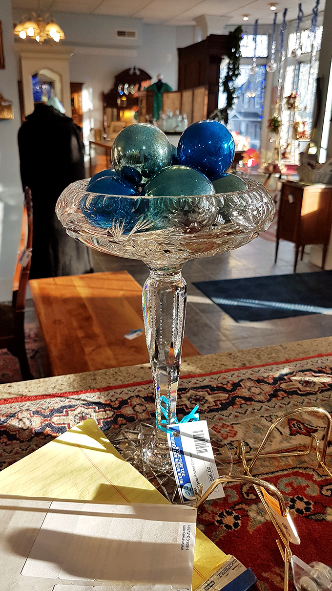 A crystal compote cradles blue ornaments like precious gems. In the antique world, even the display pieces become part of the story.
