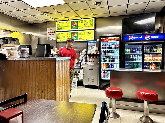 The counter where hopes and hunger meet. Those vintage menu boards have witnessed thousands of "I'll take a large cheese" declarations.