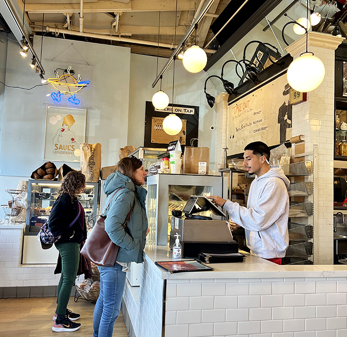 The counter where deli dreams come true, one order at a time. Notice nobody's checking their phones&mdash;the food demands full attention.
