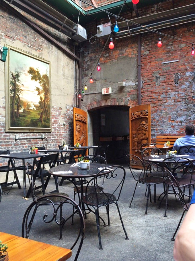 The courtyard feels like stumbling into a secret garden party. Exposed brick, twinkling lights, and carved wooden doors create an urban oasis.