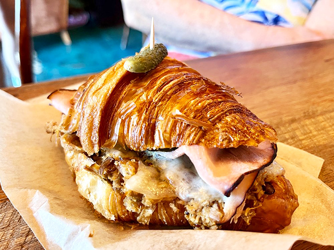 A croissant sandwich so perfectly layered it deserves its own Instagram account. That pickle on top is the exclamation point.