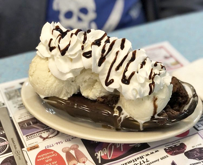 This brownie sundae doesn't just satisfy a sweet tooth—it throws a party for it. That hot fudge river flowing beneath vanilla islands is pure dessert geography.