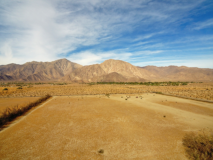 Mountains frame the desert landscape like nature's own theater backdrop, setting the stage for artistic adventures.