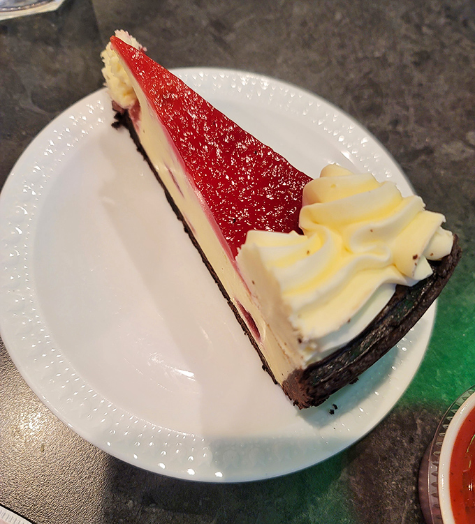 This slice of cheesecake with its ruby-red topping isn't just dessert; it's the grand finale your taste buds have been waiting for.