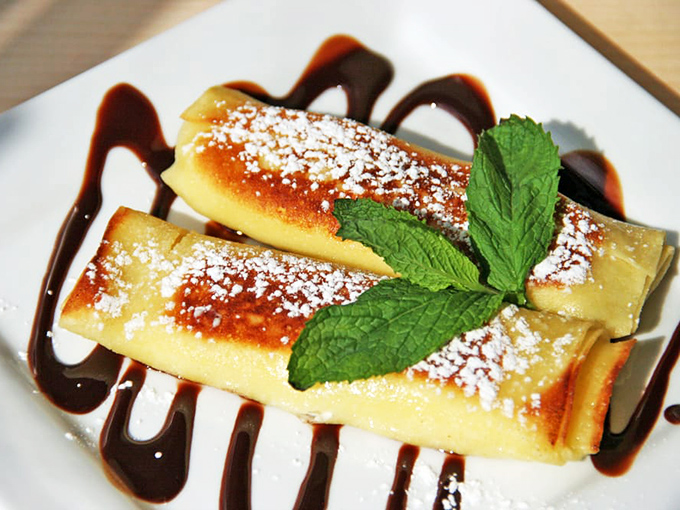Sweet cheese pierogi with chocolate sauce isn't fusion cuisine&mdash;it's tradition in dessert form, where powdered sugar snow falls on pillowy dumplings.