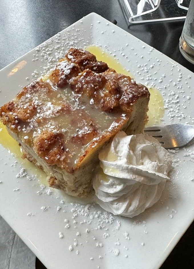 This dessert arrives looking like golden treasure, dusted with powdered sugar dreams and whipped cream.